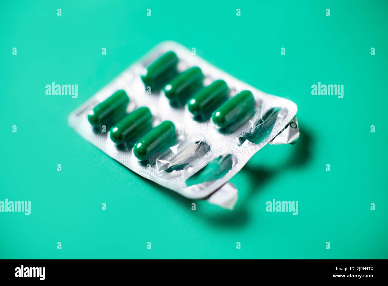 Started packing of tablets with green capsules. Green background ...