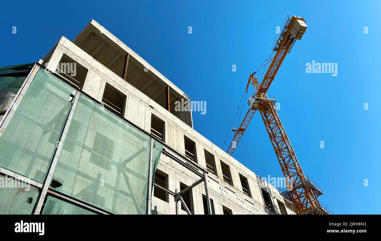 Tower building crane against the blue sky and sun. Construction of new ...