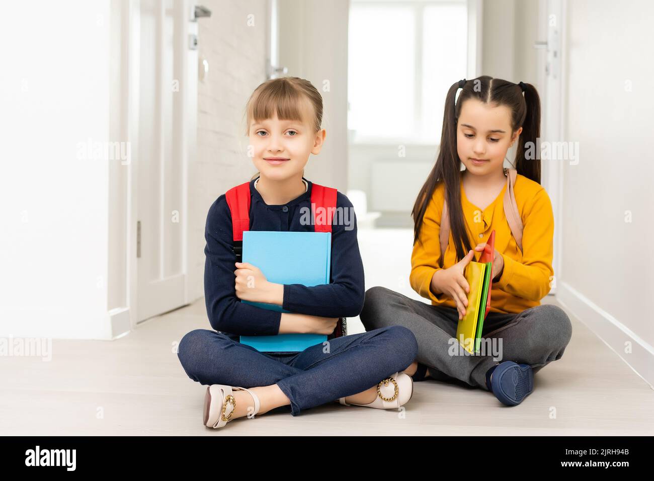two pretty young schoolgirls. girls carry notebooks Stock Photo - Alamy