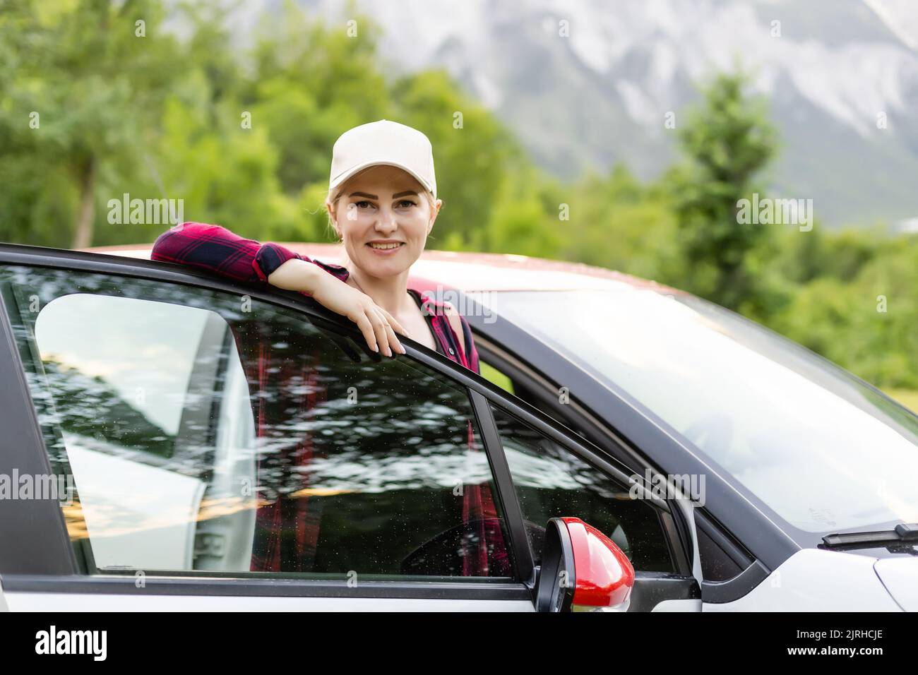 Happy driver woman against mountains background. Summer vacations ...