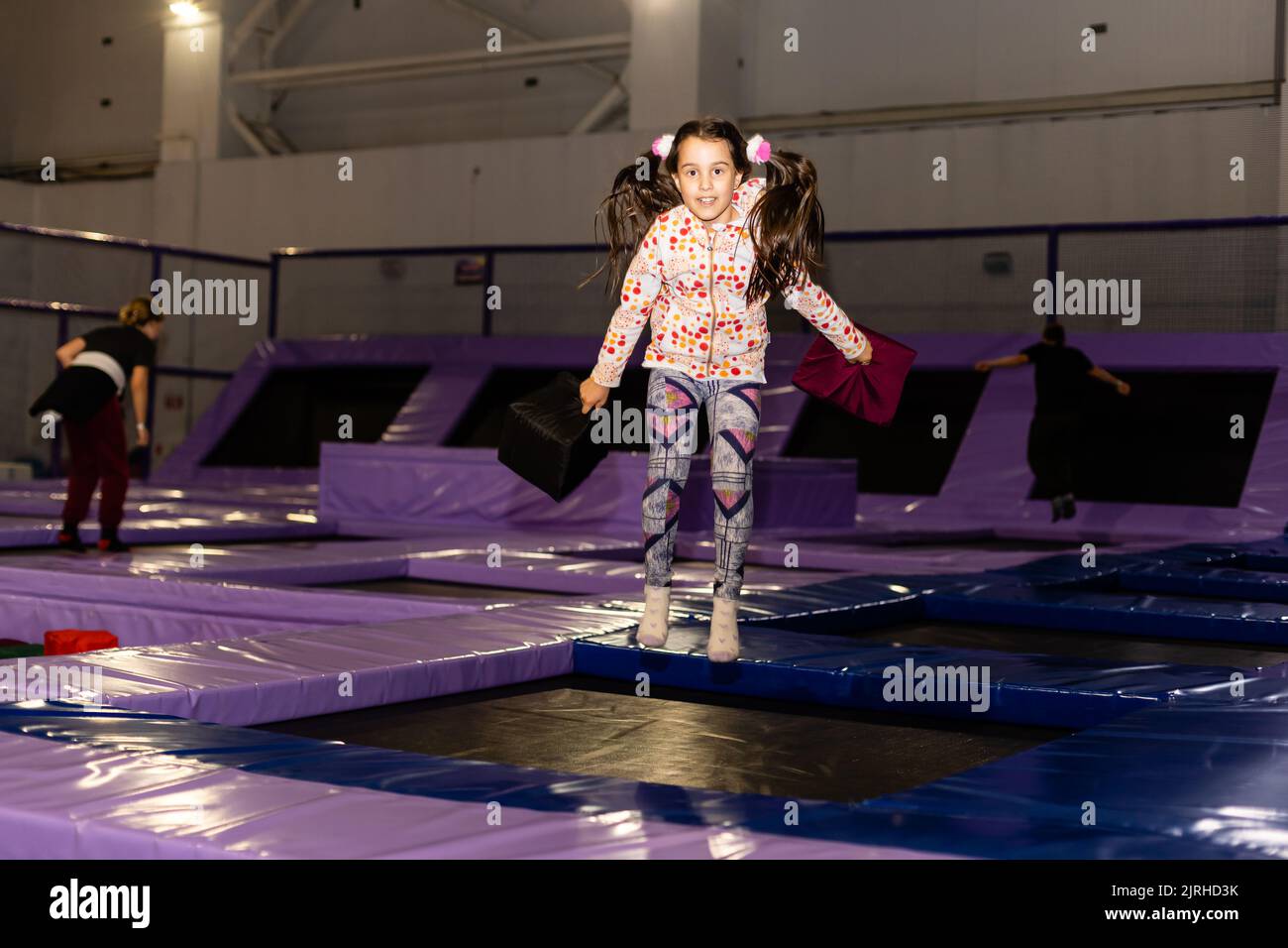 Little child jumping at trampoline in indoors playground. Active ...