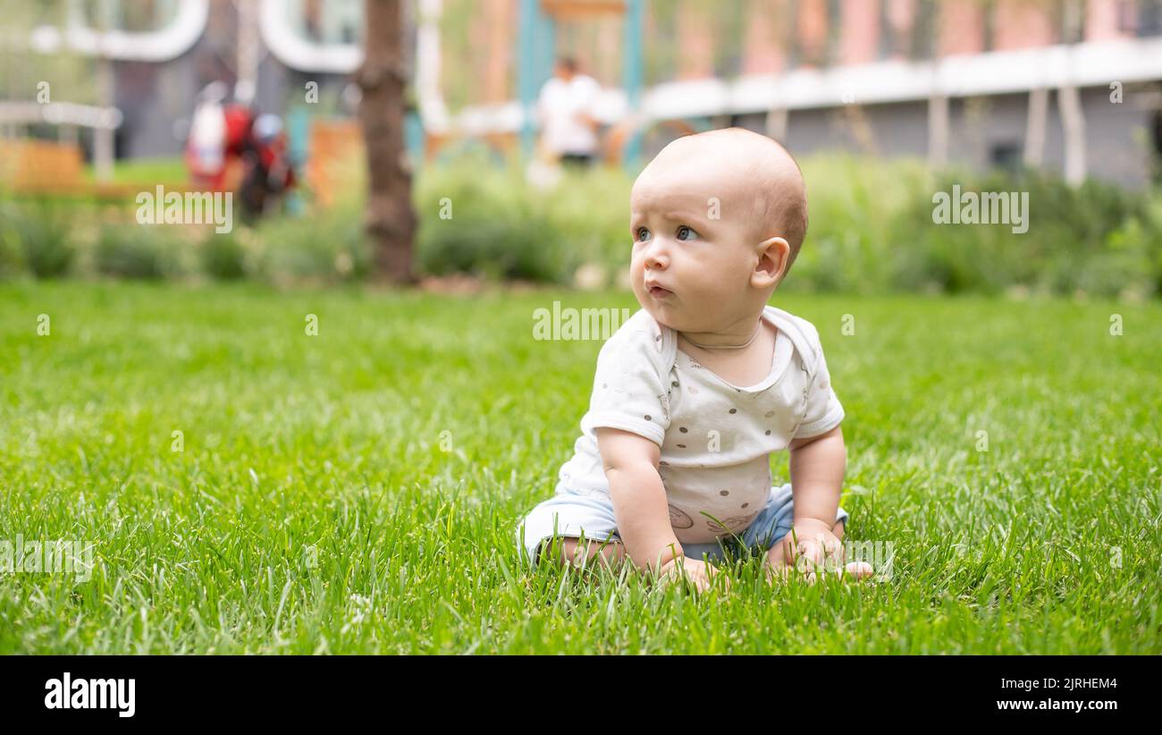 Little baby on fresh green grass outdoors Stock Photo - Alamy