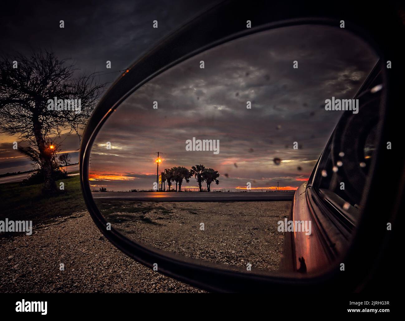 The sunset is reflected in a car mirror, January 7, 2016, at Cedar ...