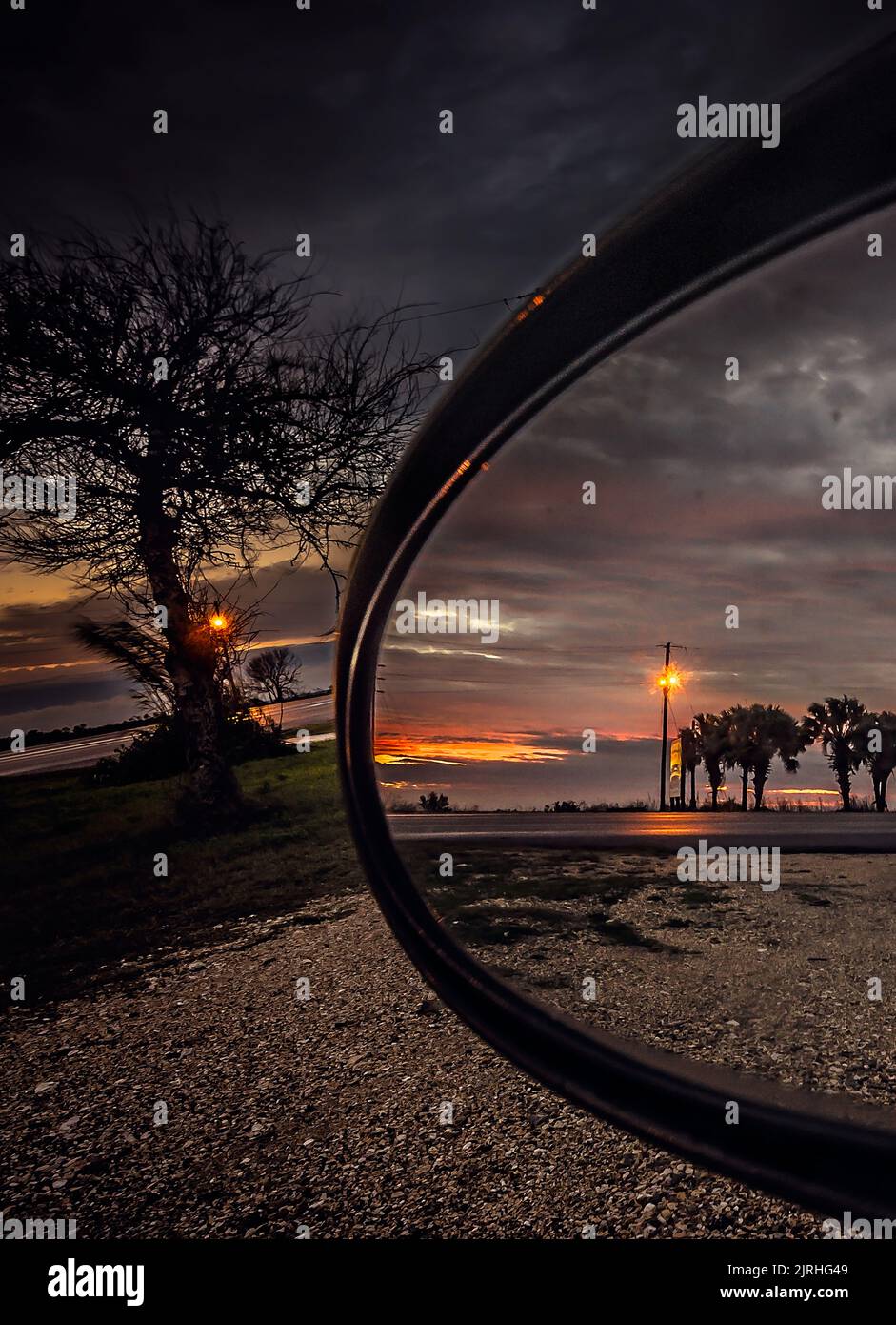 The sunset is reflected in a car mirror, January 7, 2016, at Cedar ...