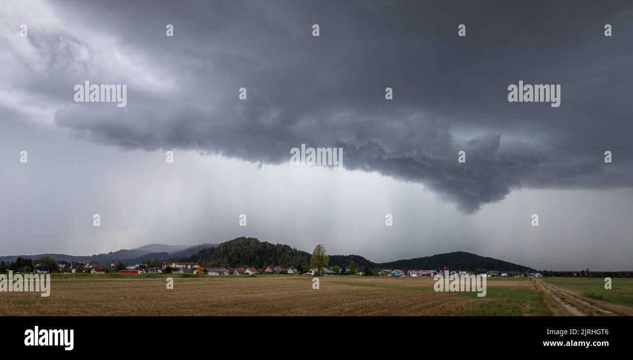 Destructive supercell storm bringing rain and wind over the farm field ...