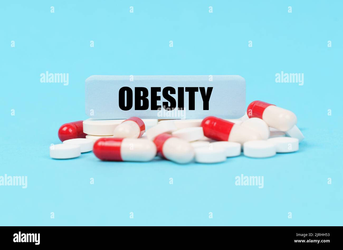 Medical concept. On the blue surface of the pills, capsules and a plate with the inscription ...