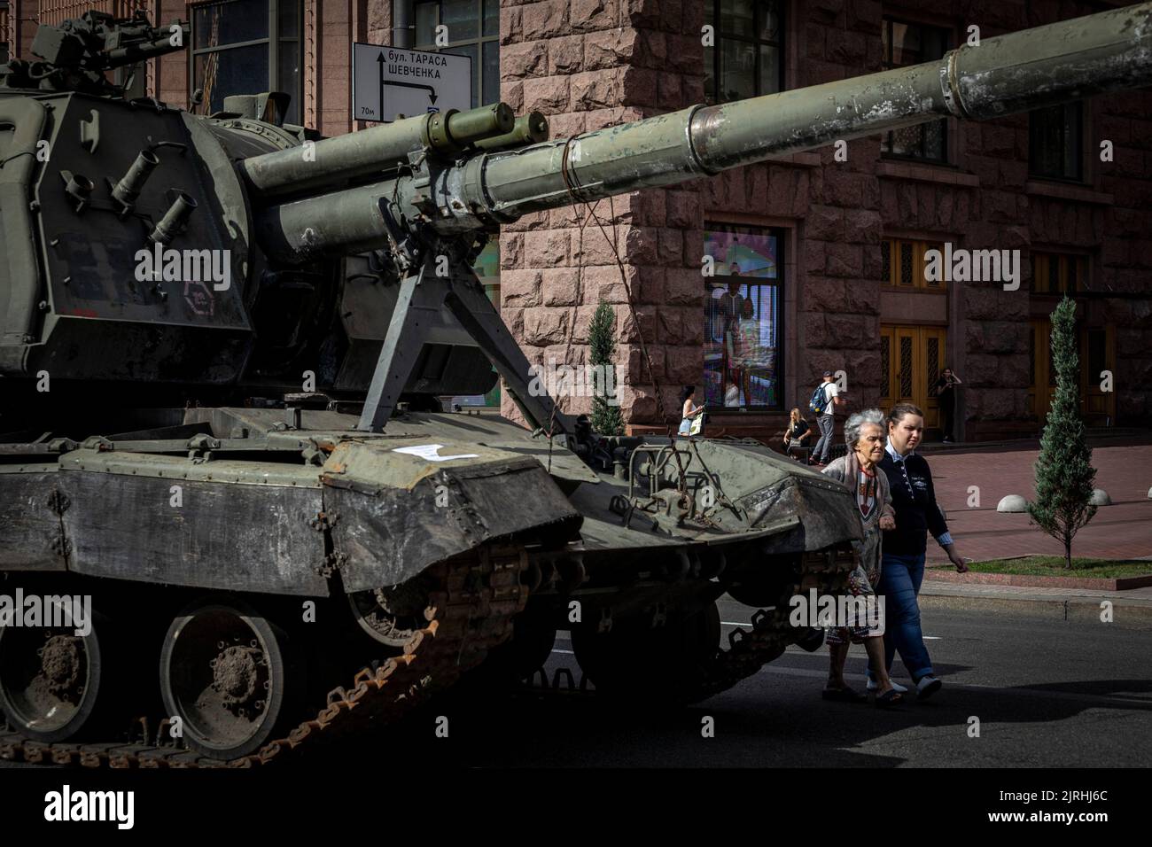 A woman and her elder mother walk past a destroyed Russian artillery ...