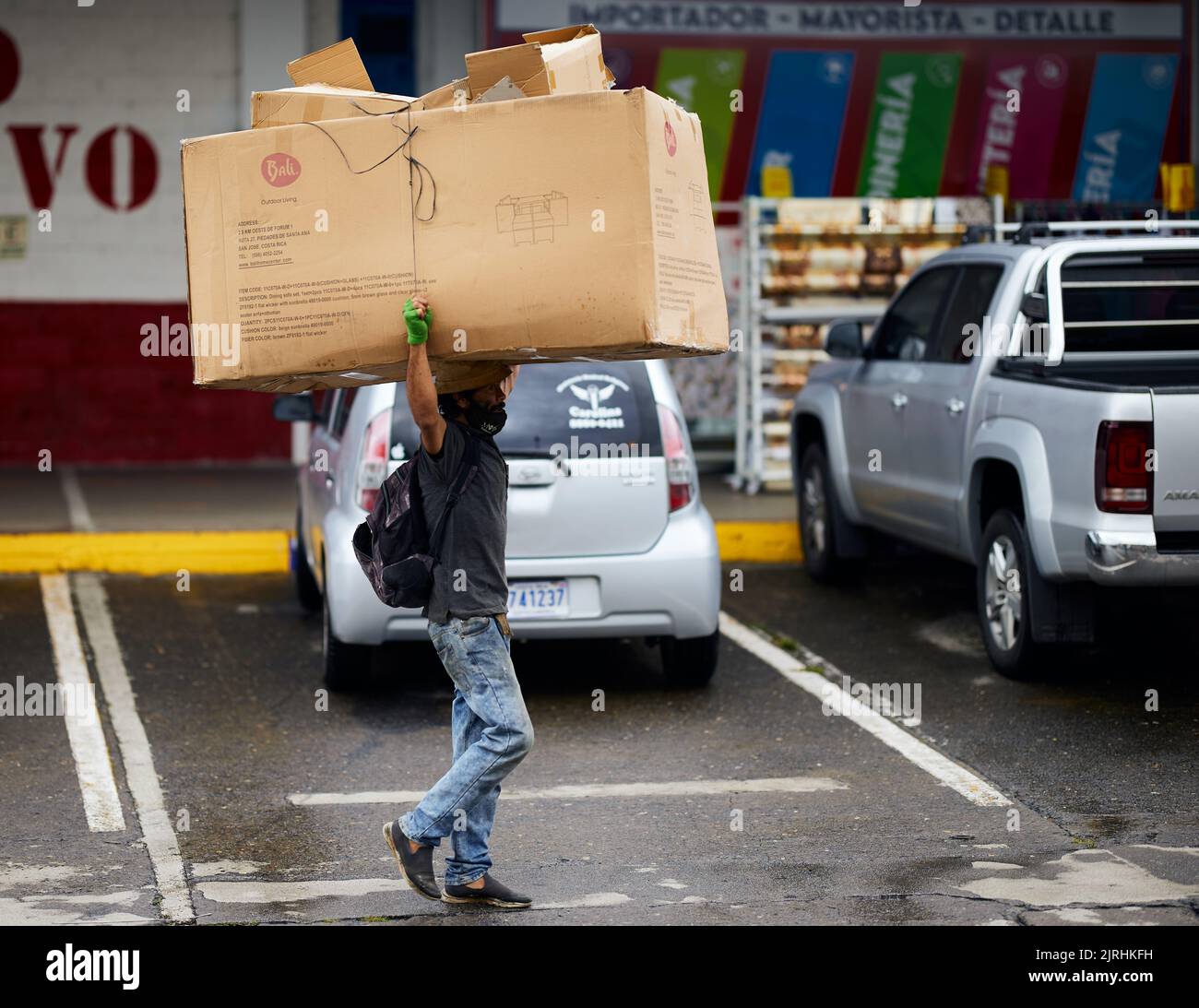 A person taking a giant cartoon box over his head on a rainy day Stock ...