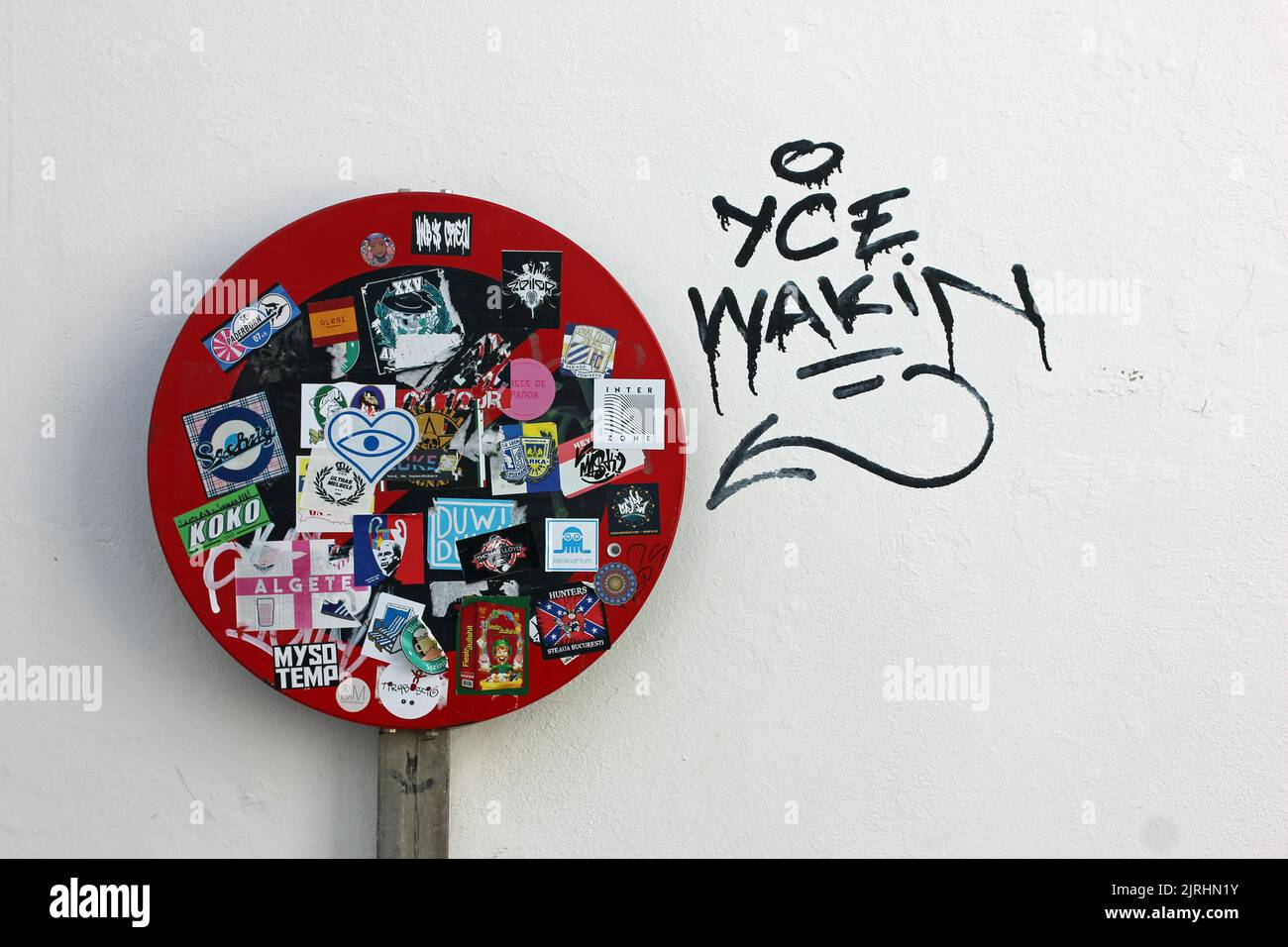 Sign with stickers in front of a white wall Stock Photo - Alamy