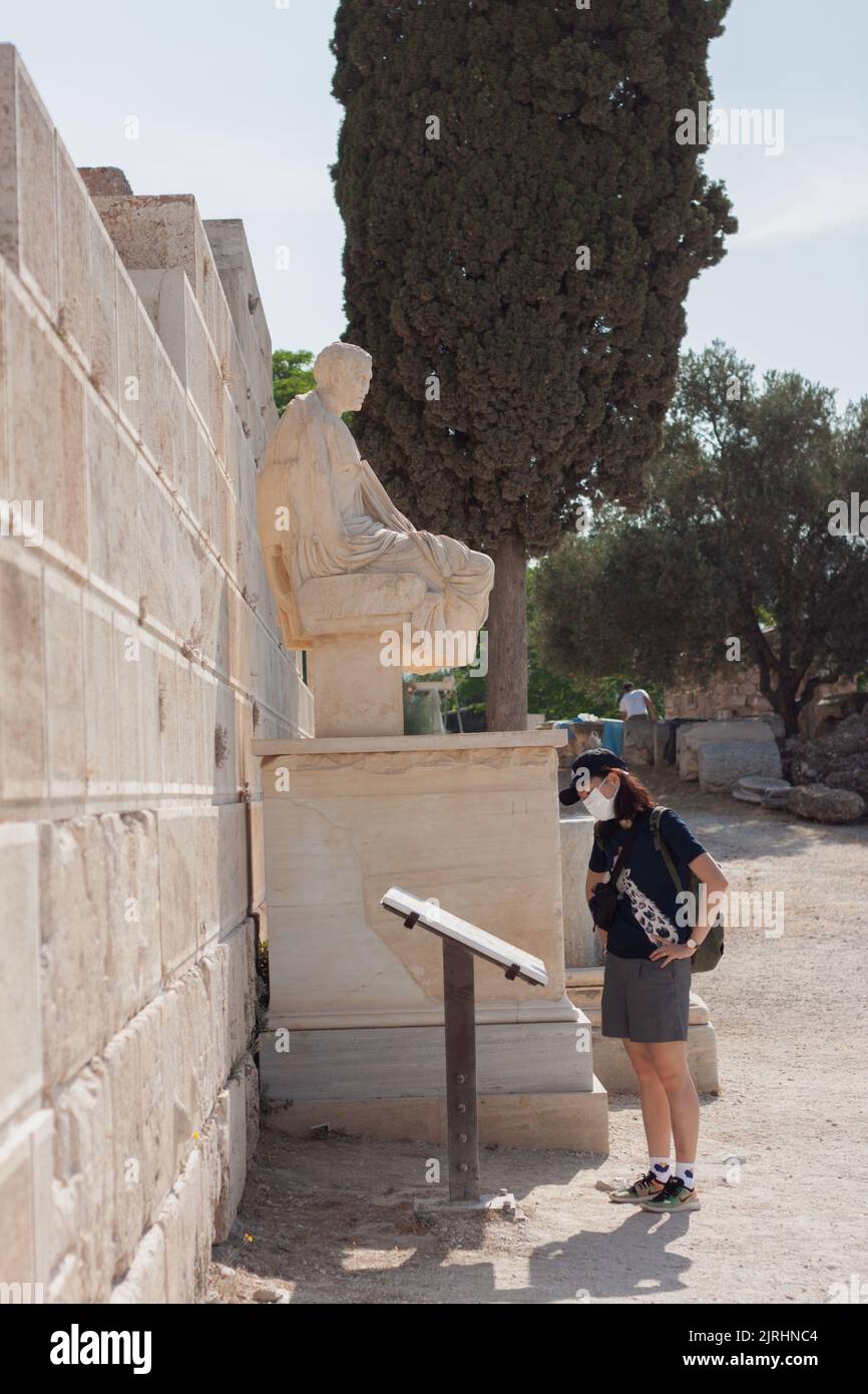 A vertical shot of the tourist reading about the Theatre of Dionysus ...