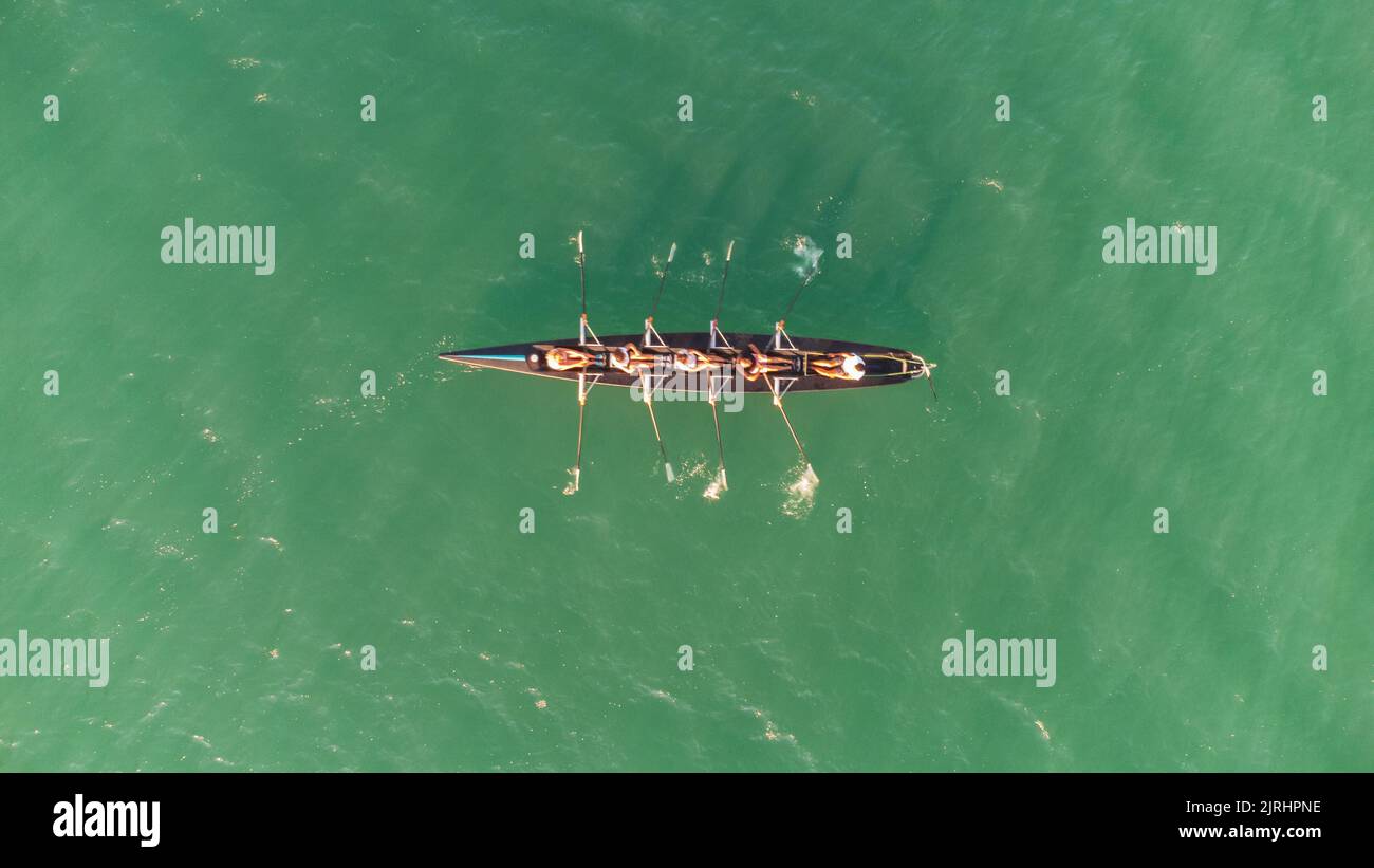 rowing team paddles on the tranquil sea Stock Photo - Alamy