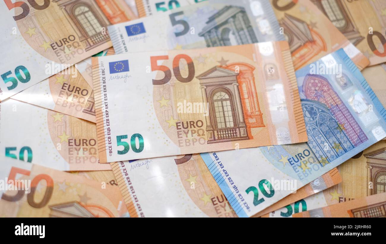 The background consists of many euro banknotes of different ...
