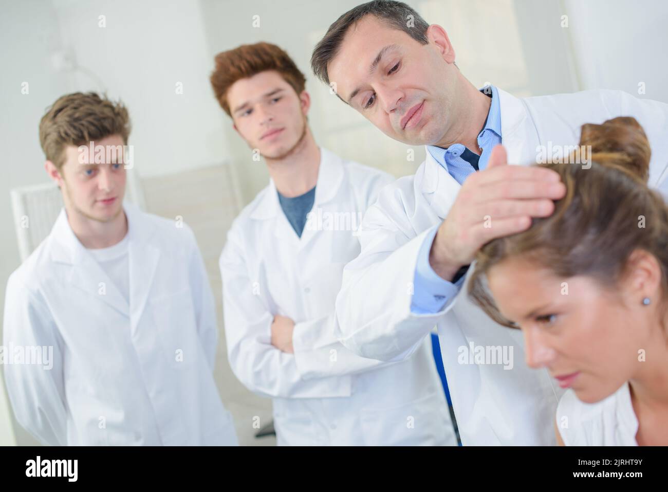Doctor demonstrating on patient to onlooking students Stock Photo - Alamy