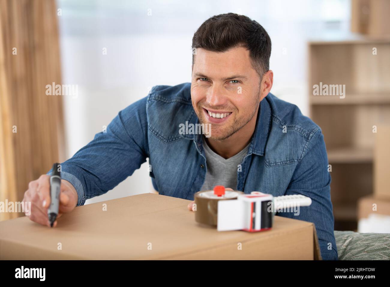 man writing on a cardboard box Stock Photo - Alamy