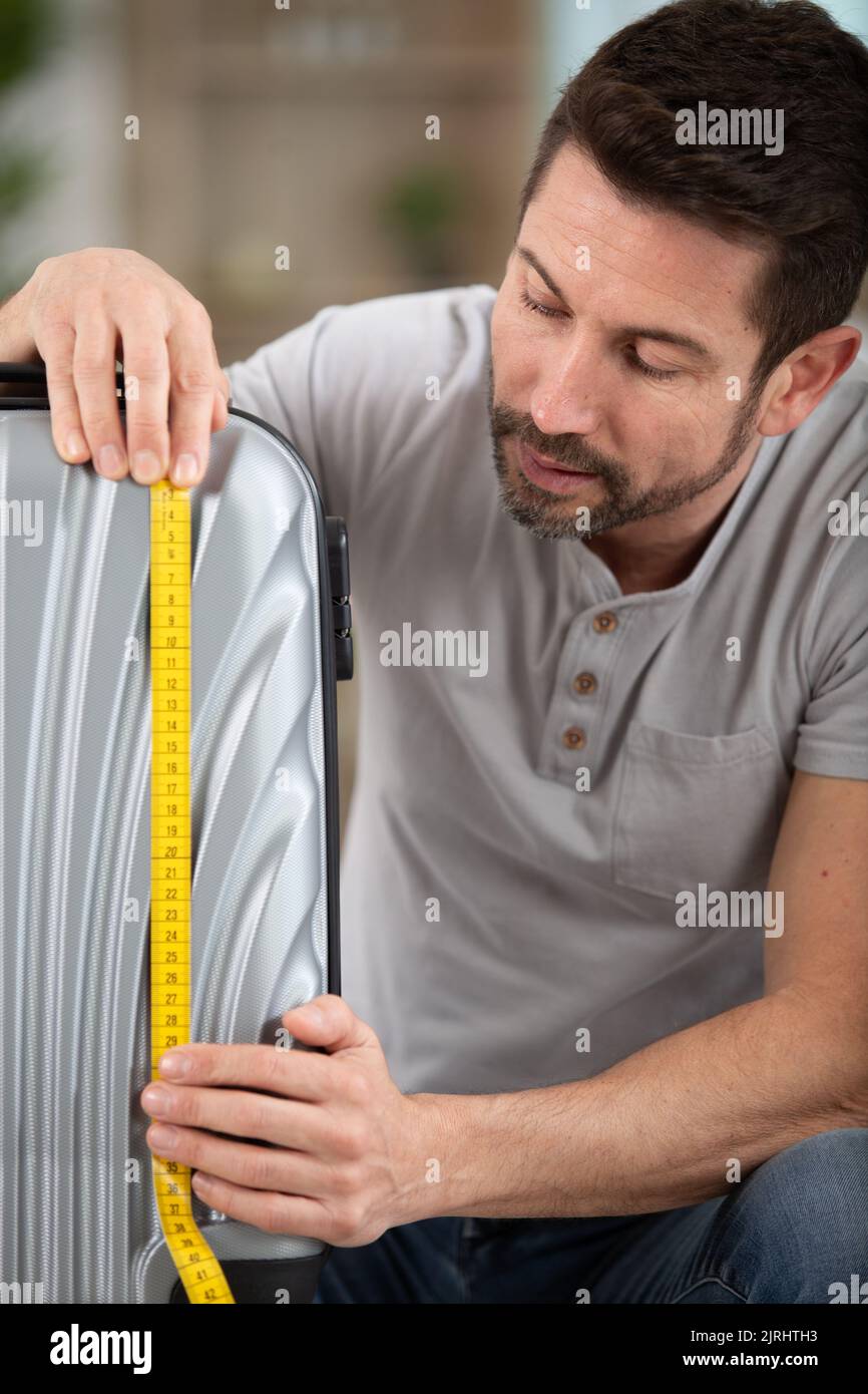 preparation before traveling man measuring suitcase Stock Photo - Alamy