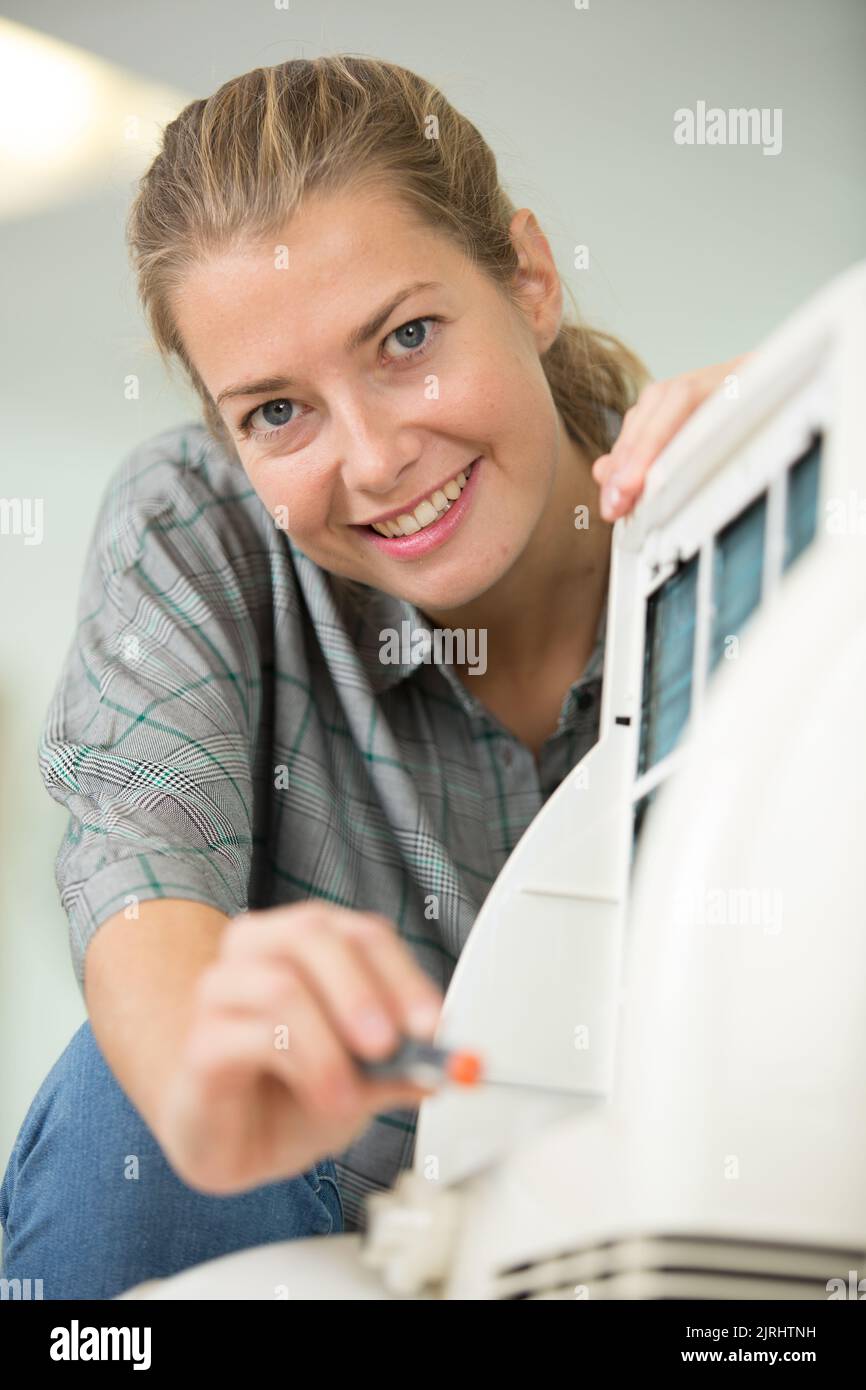 female technician fixing electric device Stock Photo - Alamy