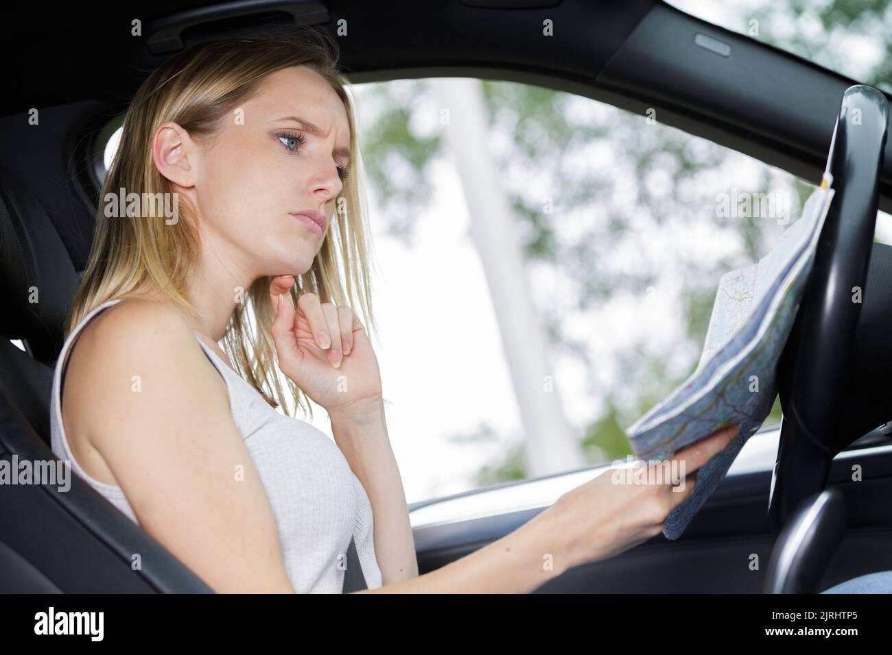 female driver looking at map Stock Photo - Alamy