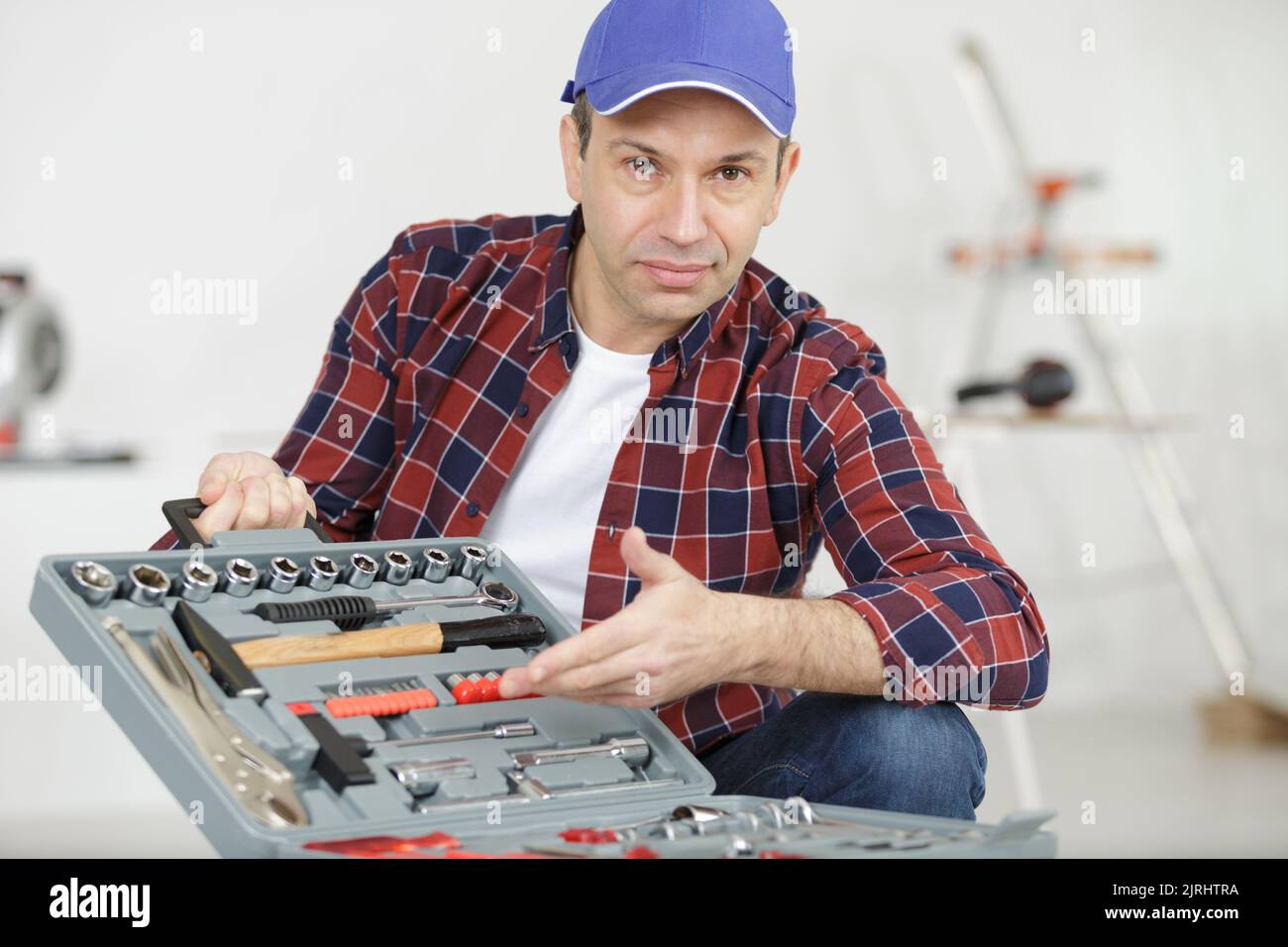 man worker displaying his workplace and tools Stock Photo - Alamy