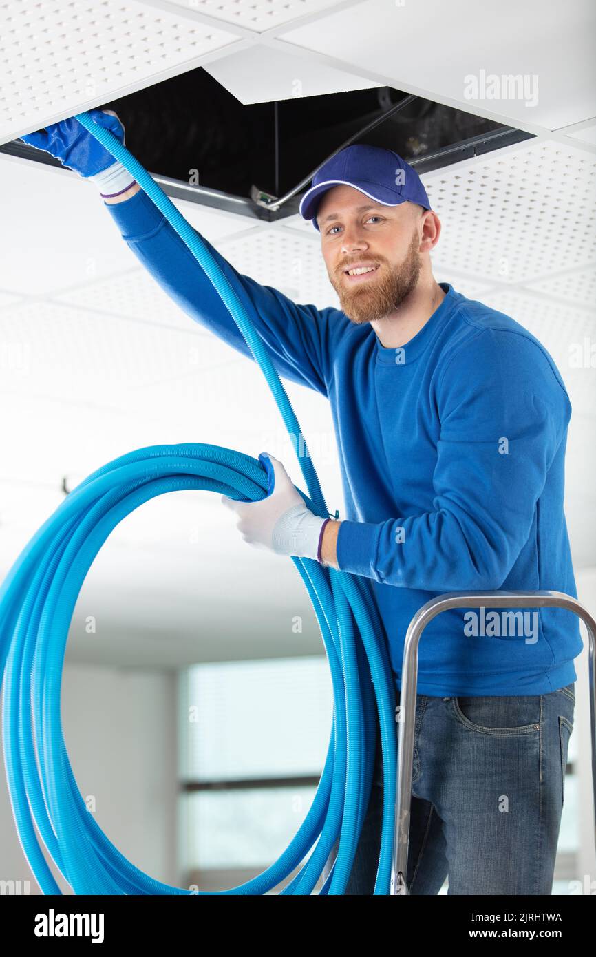 contractor fitting ceiling vent pipes Stock Photo - Alamy