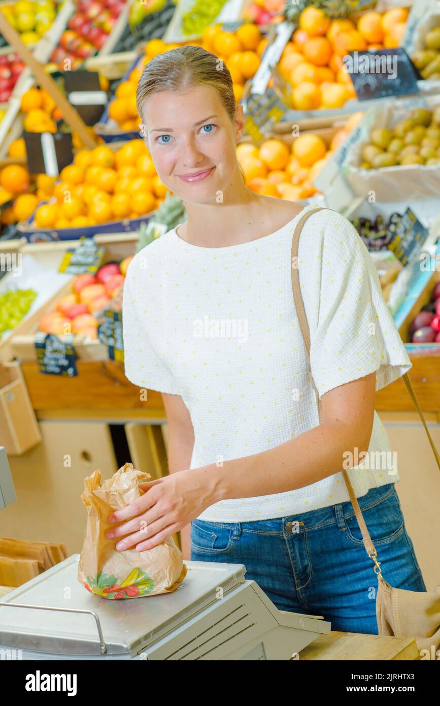 a woman is weighing fruit Stock Photo - Alamy