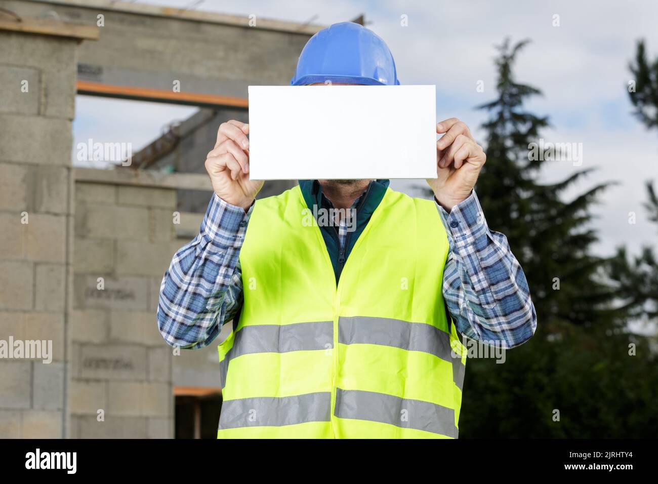 male builder showing a sign Stock Photo - Alamy