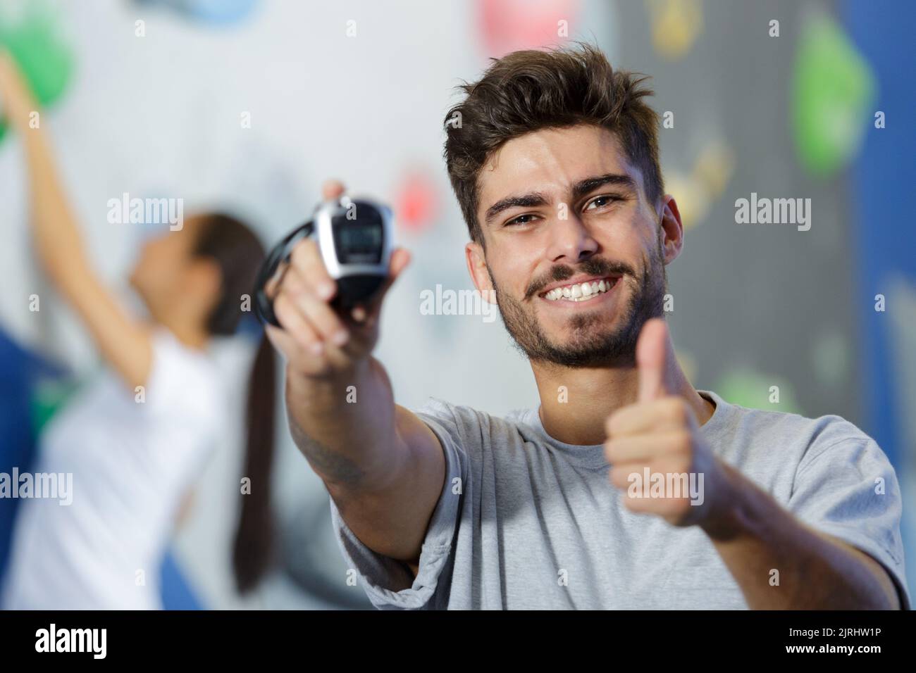 sportsman showing time on wristwatch and making thumbs-up getsure Stock ...
