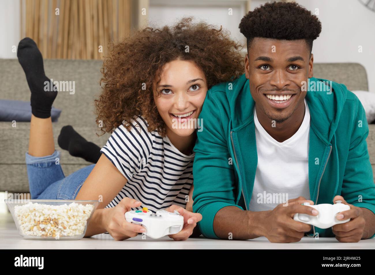 cute couple playing video games on the floor Stock Photo - Alamy