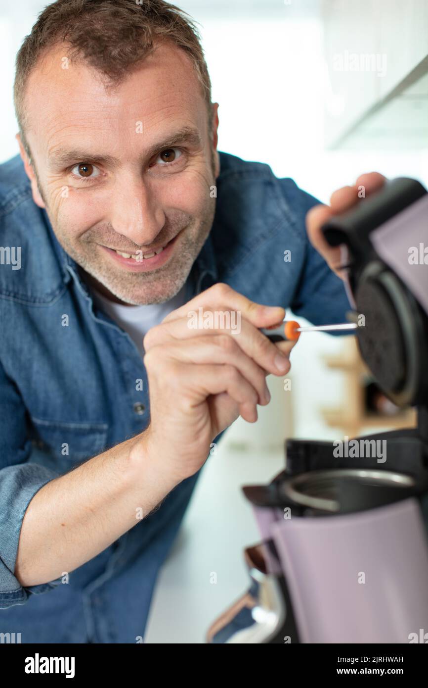 happy man repairing coffee machine in kitchen Stock Photo - Alamy
