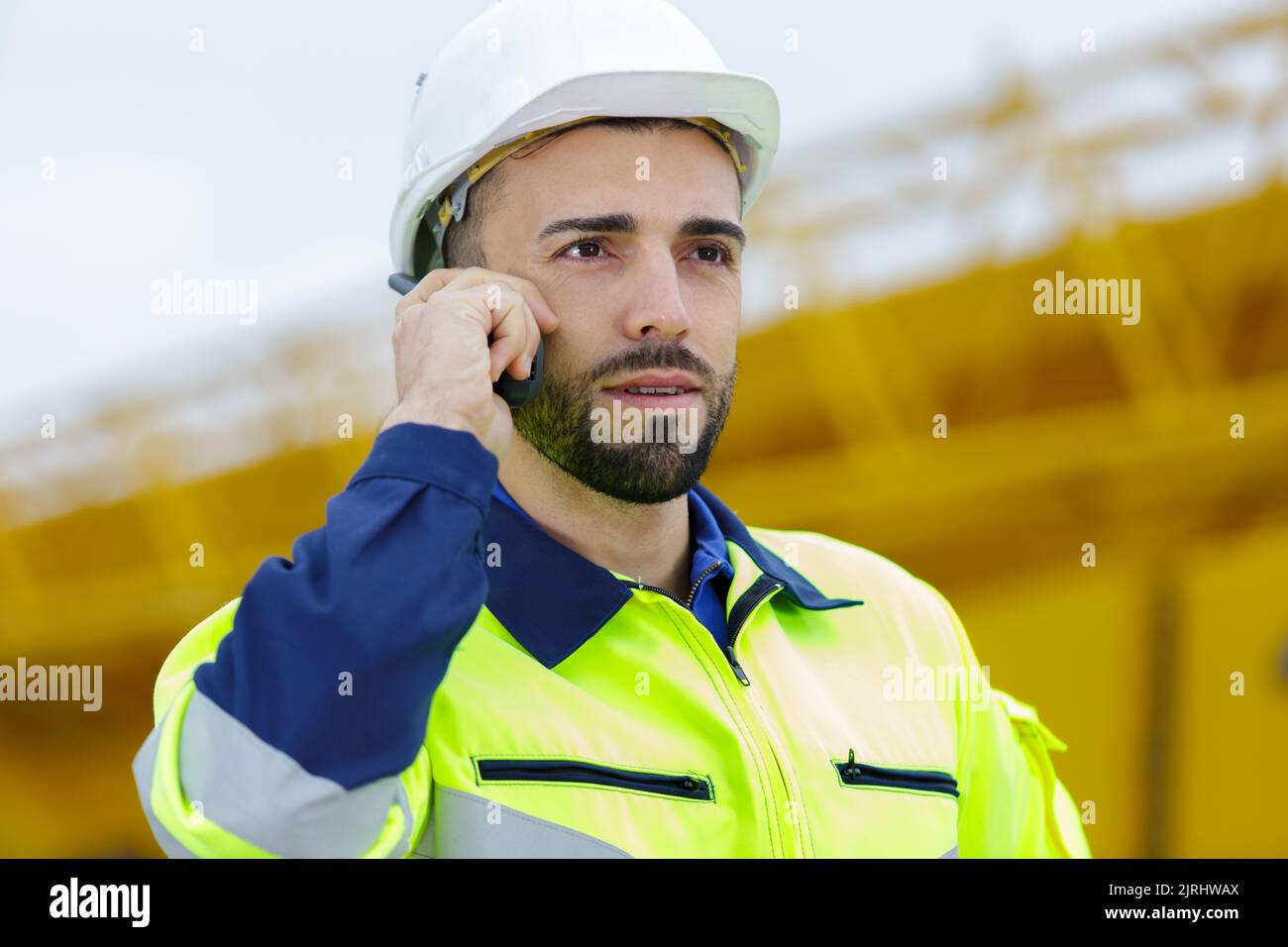 worker in overalls and helmet examine on the phone Stock Photo - Alamy