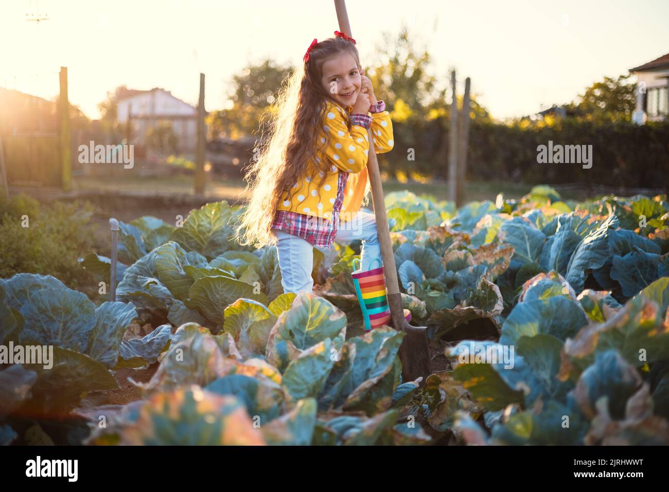 Happy little farmer girl working in a farmland field of fresh organic ...