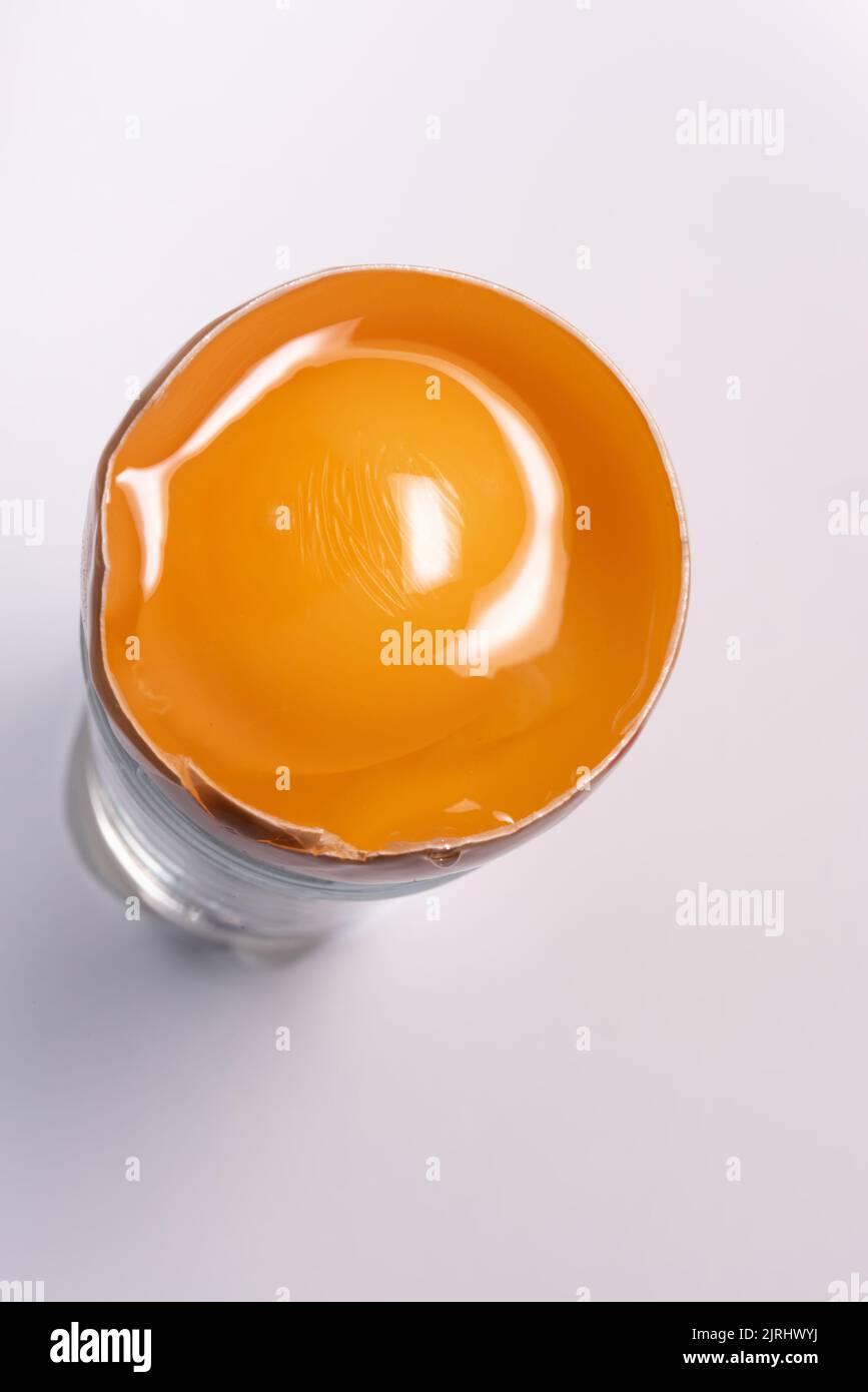 Egg yolk in a shell isolated on a white background. Egg yolk close-up ...