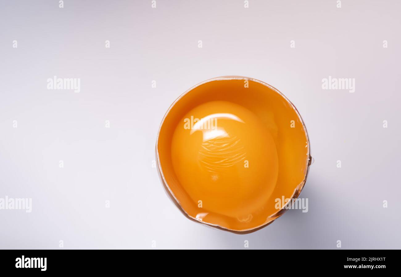 Egg yolk in a shell isolated on a white background. Egg yolk close-up ...