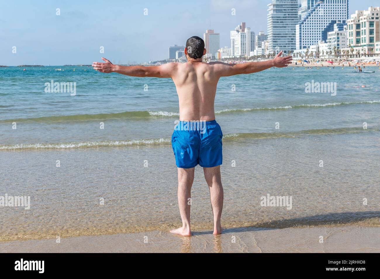 A man standing backward on a beach with arms open Stock Photo - Alamy