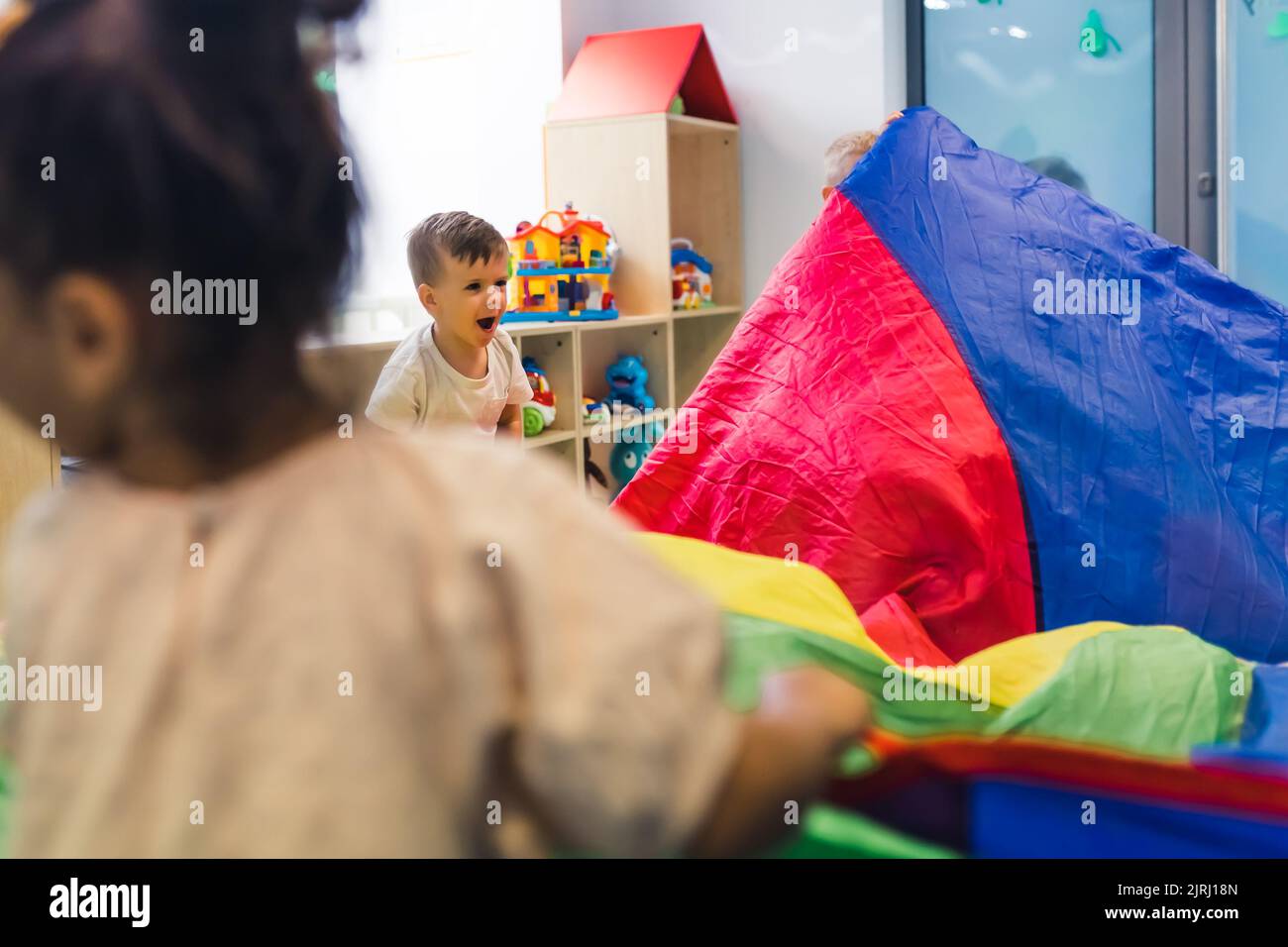 Happy toddlers having an active sensory play at the nursery school ...