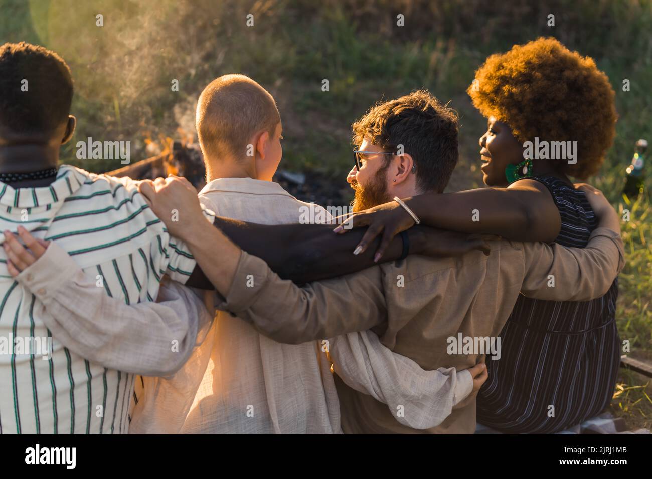 Rear view of multicultural good old friends hugging and having a ...