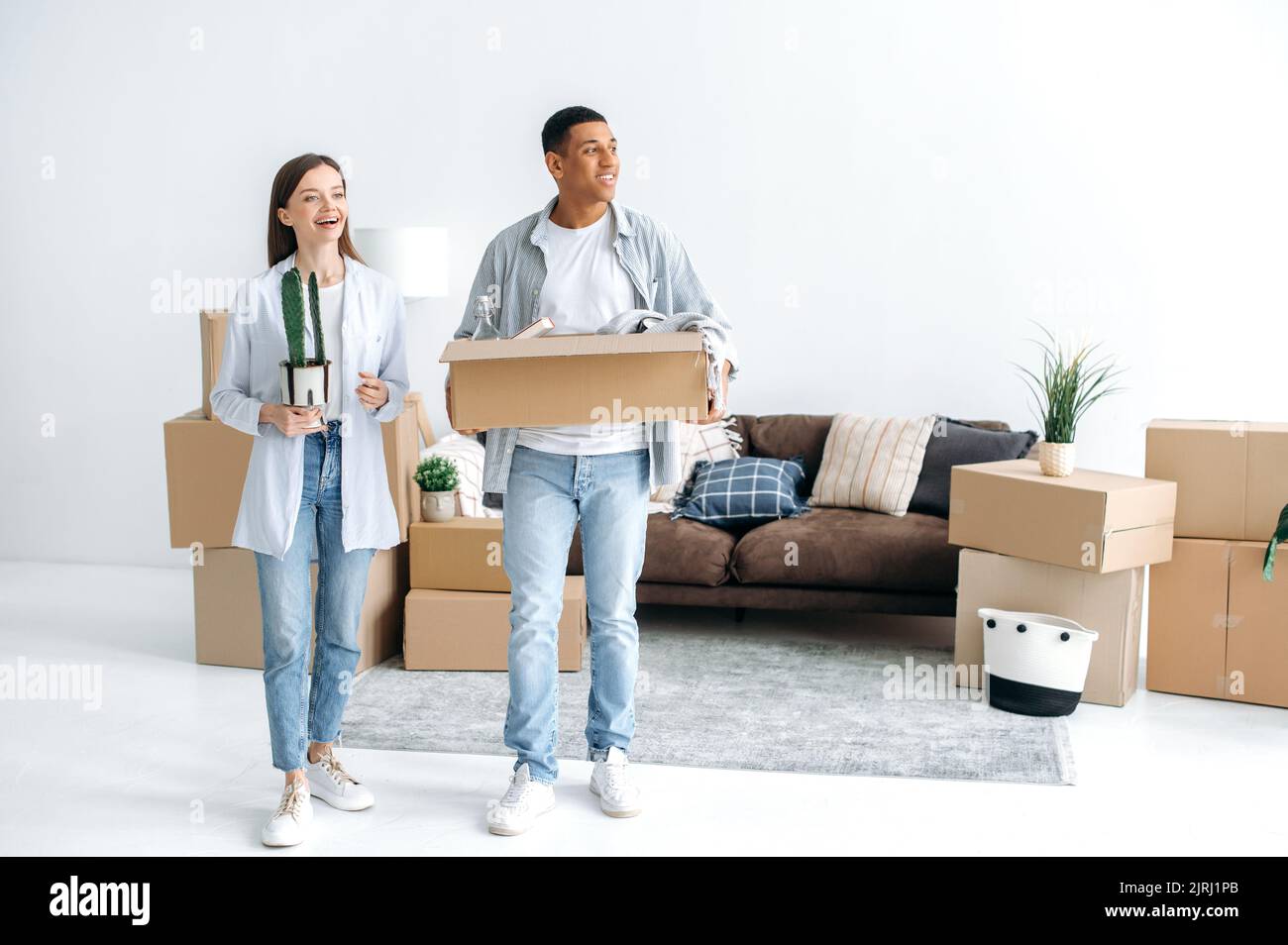 Moving to a new apartment. Happy multiracial young couple in love walk ...