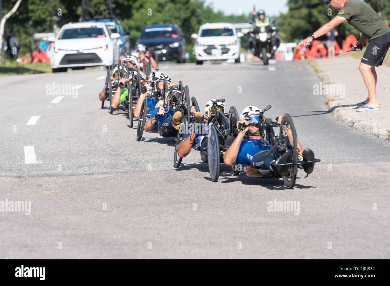 Hand cyclists follow each other down hill during the road race at the ...