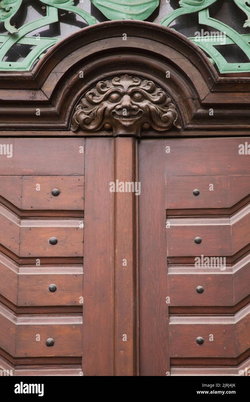 Wooden entrance door details with carved face of an imaginary mythical ...