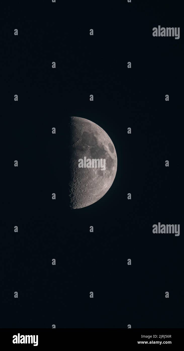 A half of moon in black sky, vertical shot Stock Photo - Alamy