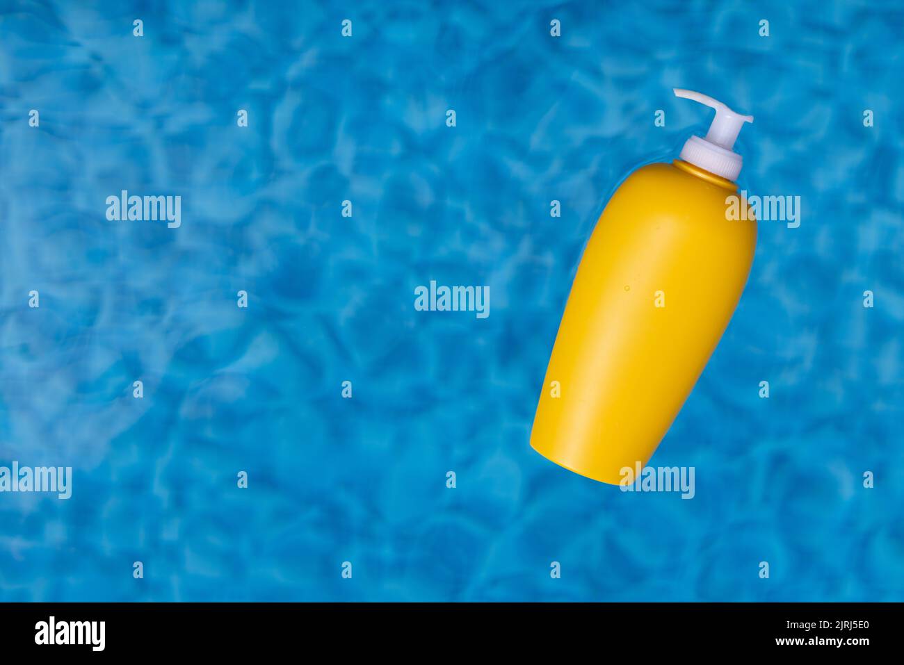 Sunscreen bottle floating in blue water of swimming pool Stock Photo ...