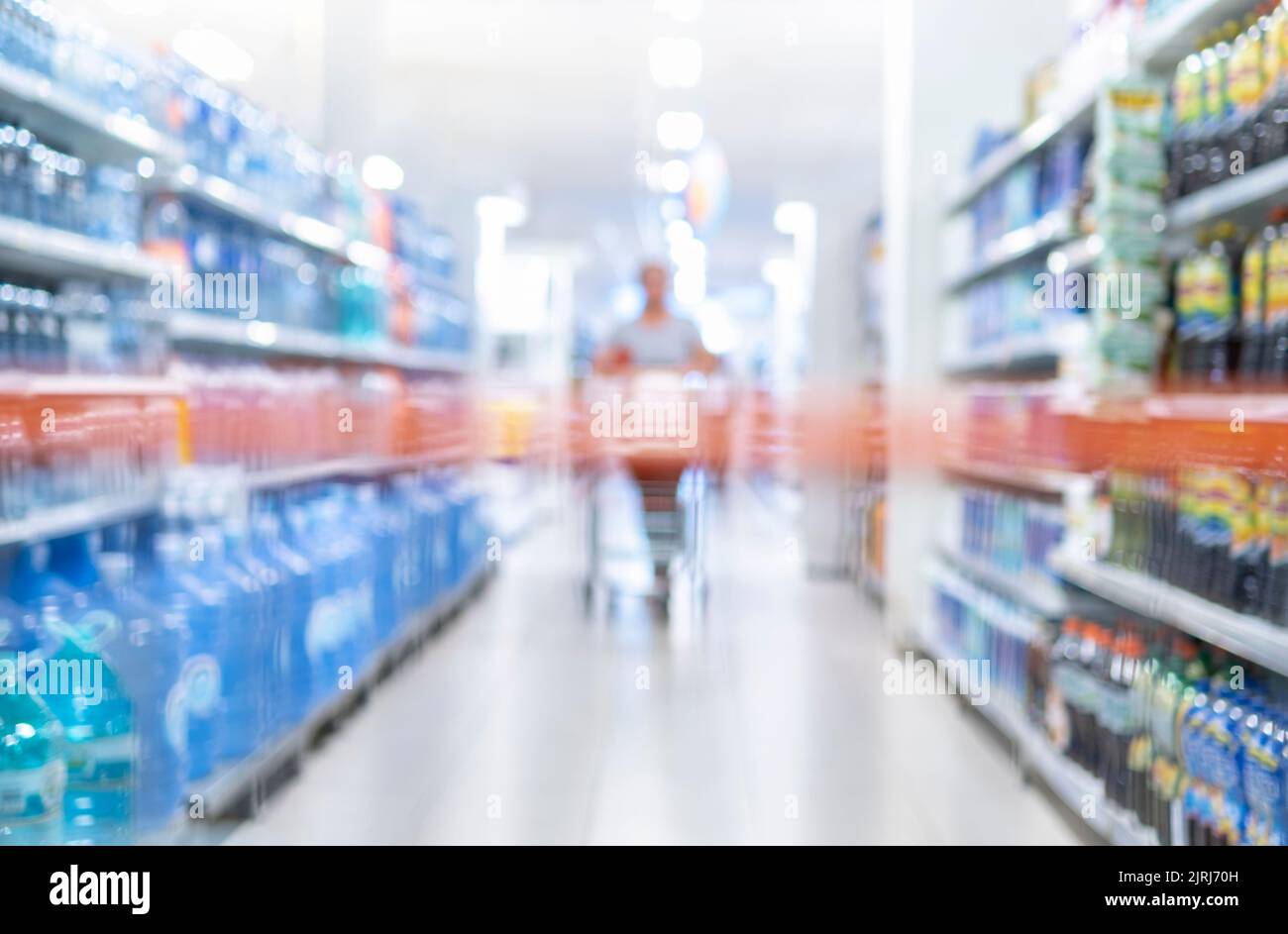 Blurred supermarket aisle with shelves of merchandise. Perspective view ...