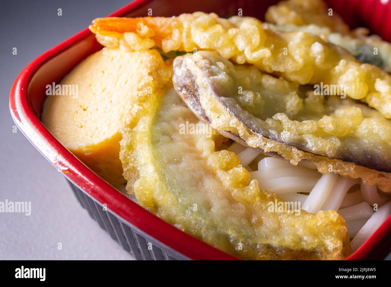 Closeup takeout Udon Bento in food container. Toppings are green onion ...