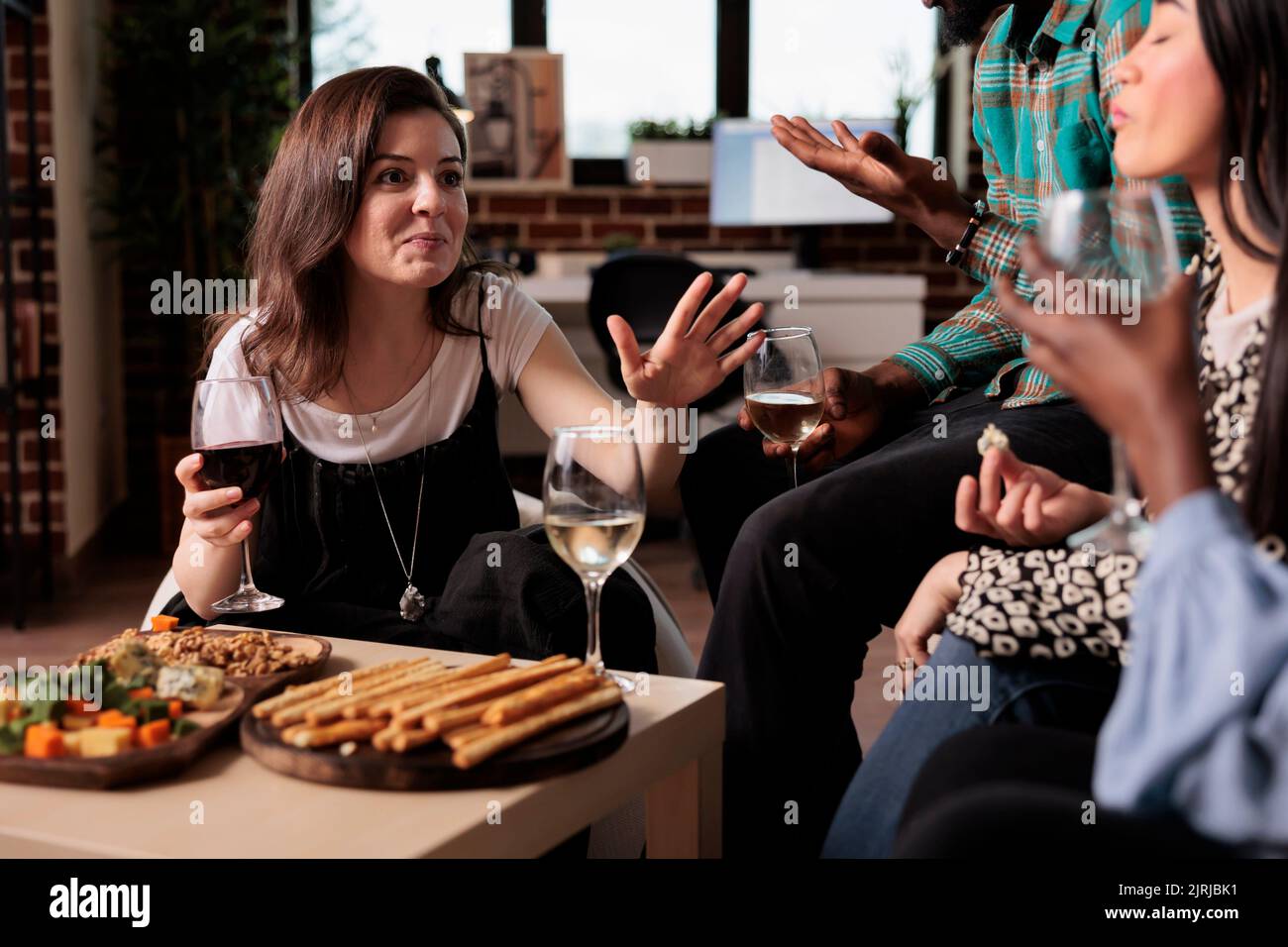 Diverse group of happy young people enjoying alcoholic beverage while ...