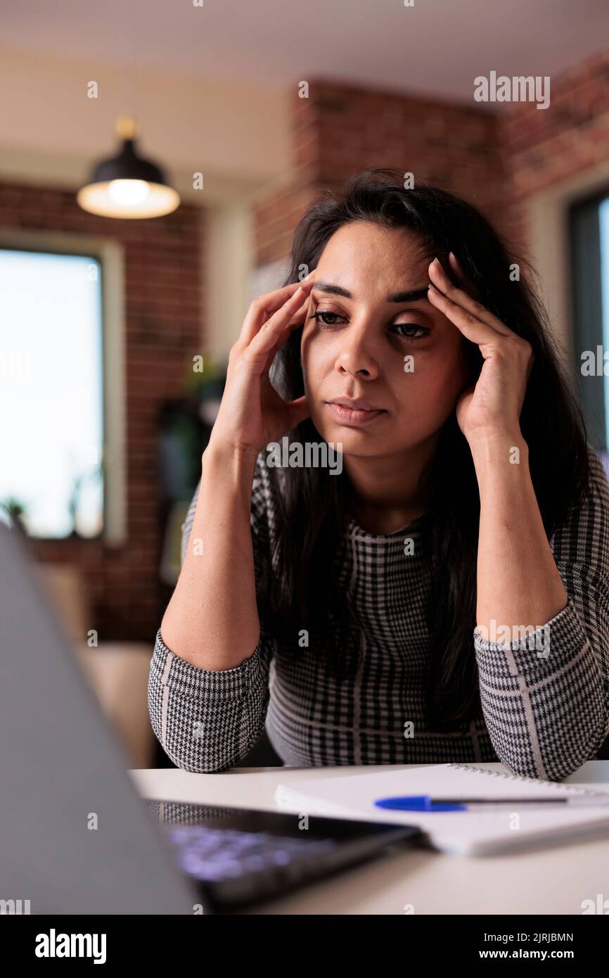 Tired freelancer working from home and feeling stressed about overload ...