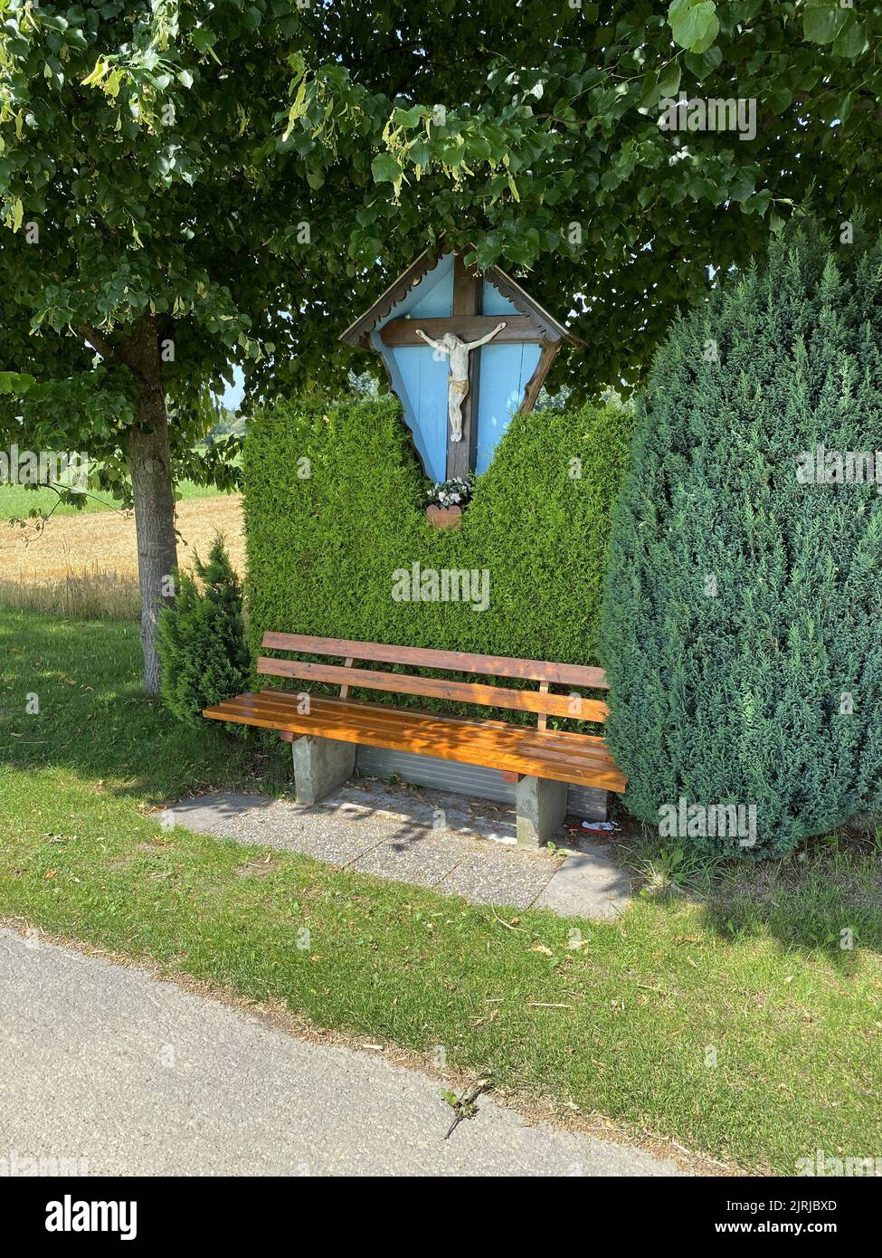 Shady Park Bench Under A Cross Stock Photo - Alamy