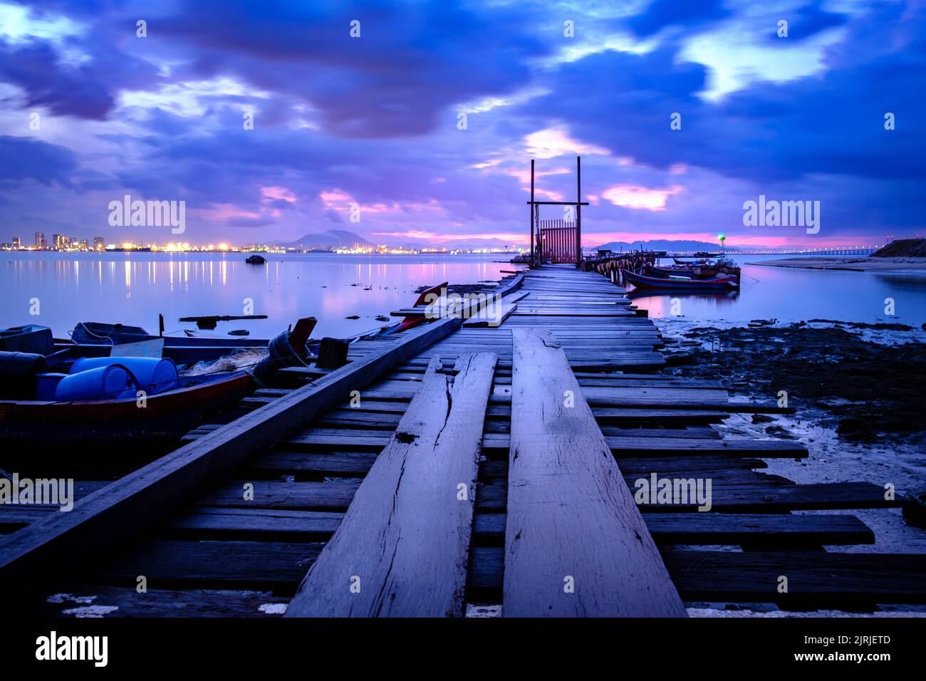 As the sun rising red wave of light emerges from the cloudy skyline ...