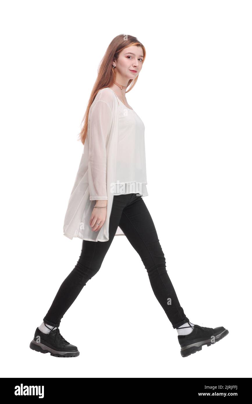 Side view of a casual young woman walking away from the camera and ...