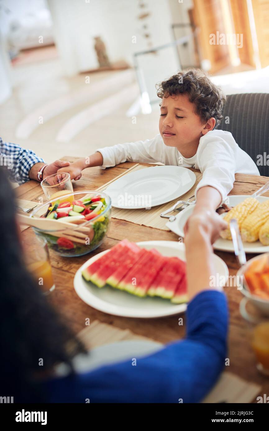 Can we start eating soon. a family praying together before enjoying a ...