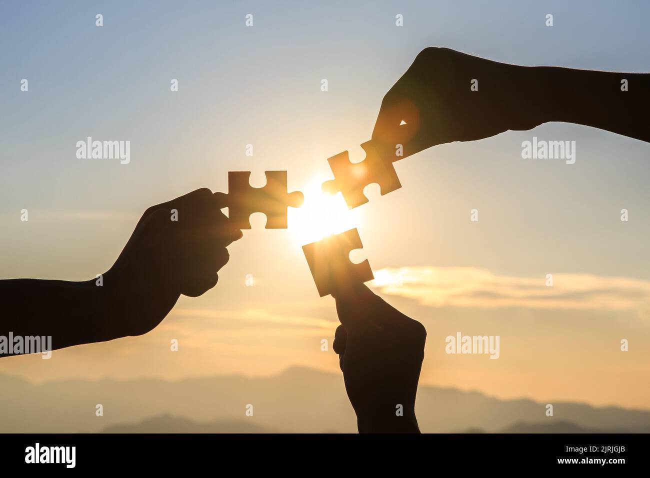 Silhouette of hand holding Jigsaw with Sunrise background. . symbol of ...