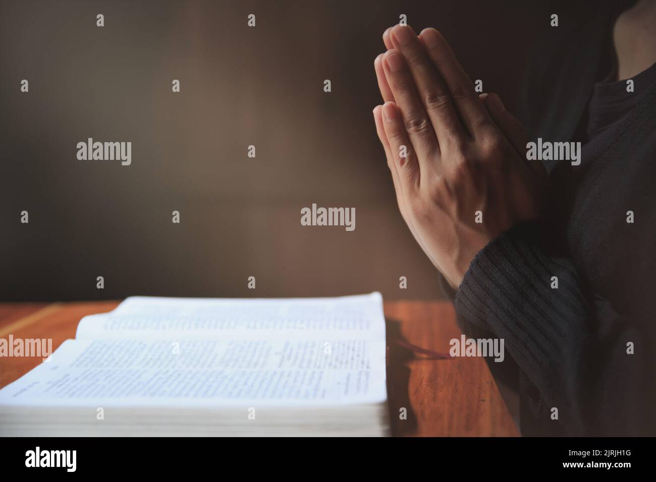 Praying hands with faith in religion and belief in God on dark ...